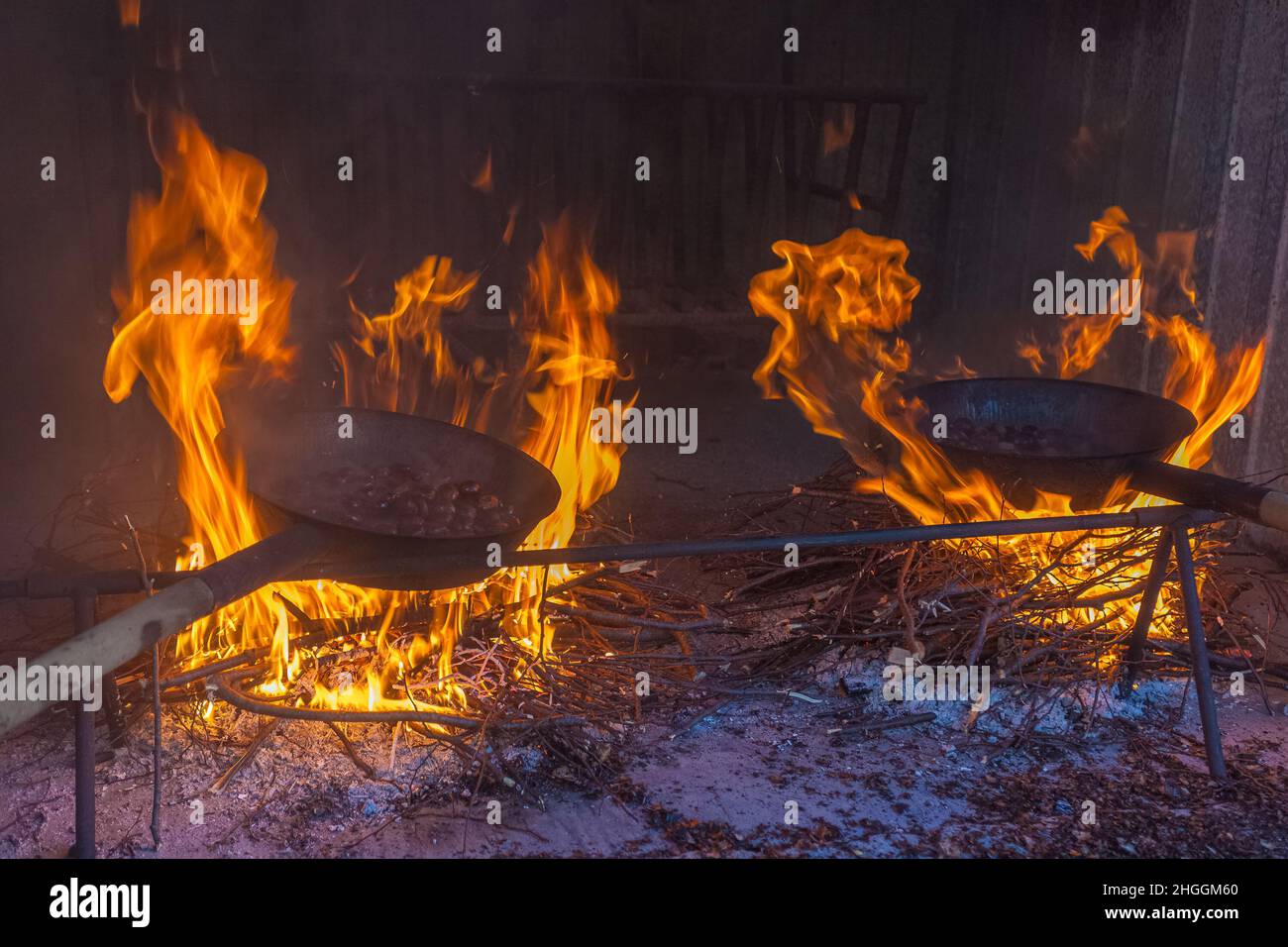 Chestnuts cooked on couple of pans over the fire Stock Photo - Alamy