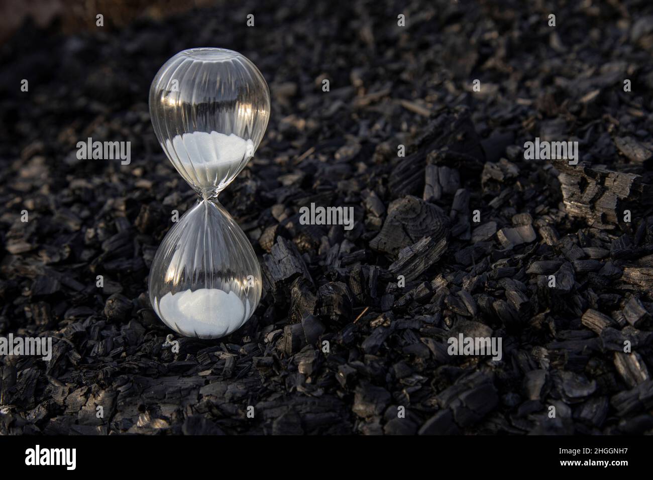Big hourglass on soot. Concept countdown, burnt forest, something burnt ...