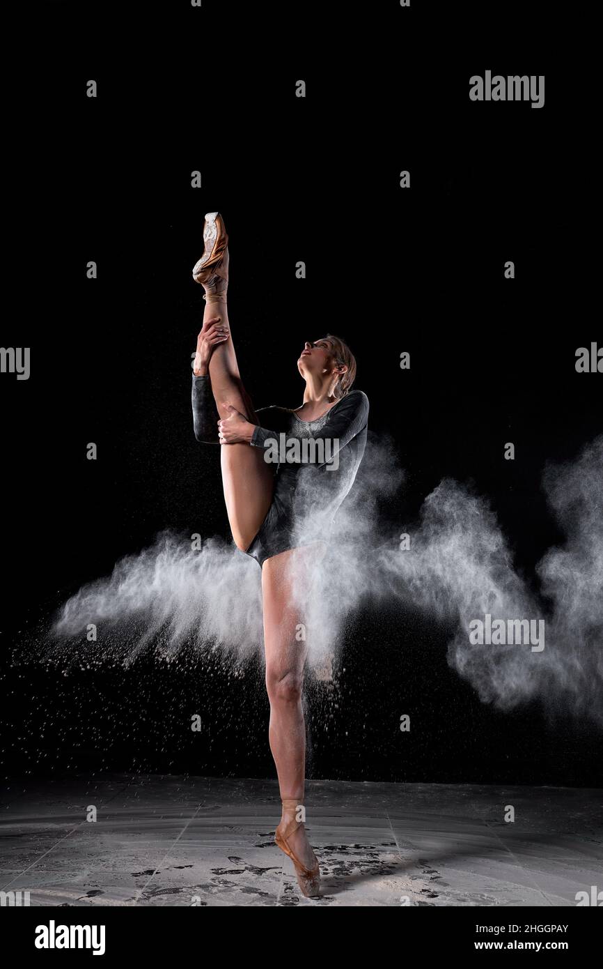Dancing in flour concept. Young beautiful female adult woman dancer in dust, fog. Lady is ...