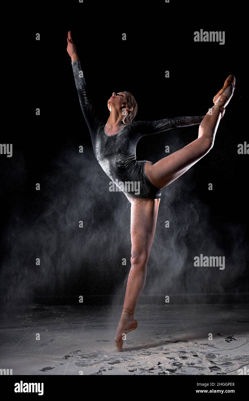 Dancing in flour concept. Pretty Gorgeous Ballerina woman dancer in dust fog. Portrait of female ...