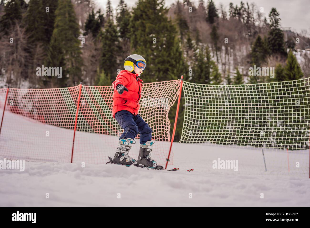 Child skiing in mountains. Active toddler kid with safety helmet ...