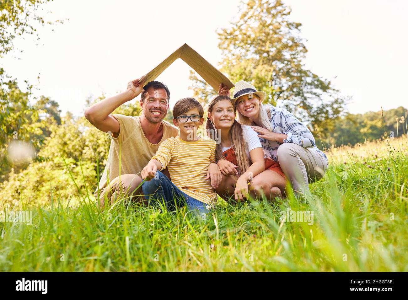 Happy family with two children with roof over their heads symbolizing ...