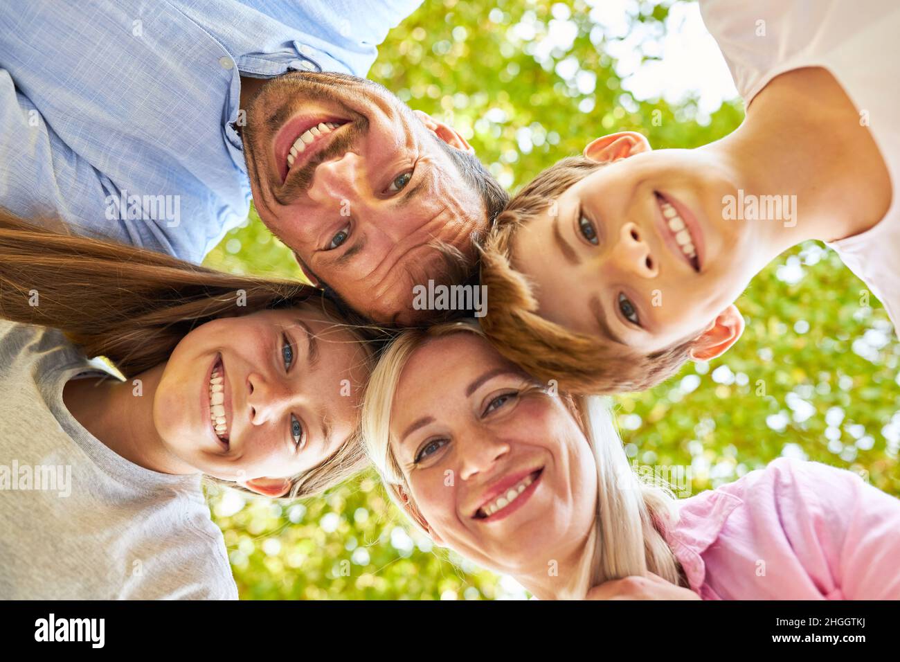 Cheerful parents and smiling children as a happy family in nature in ...