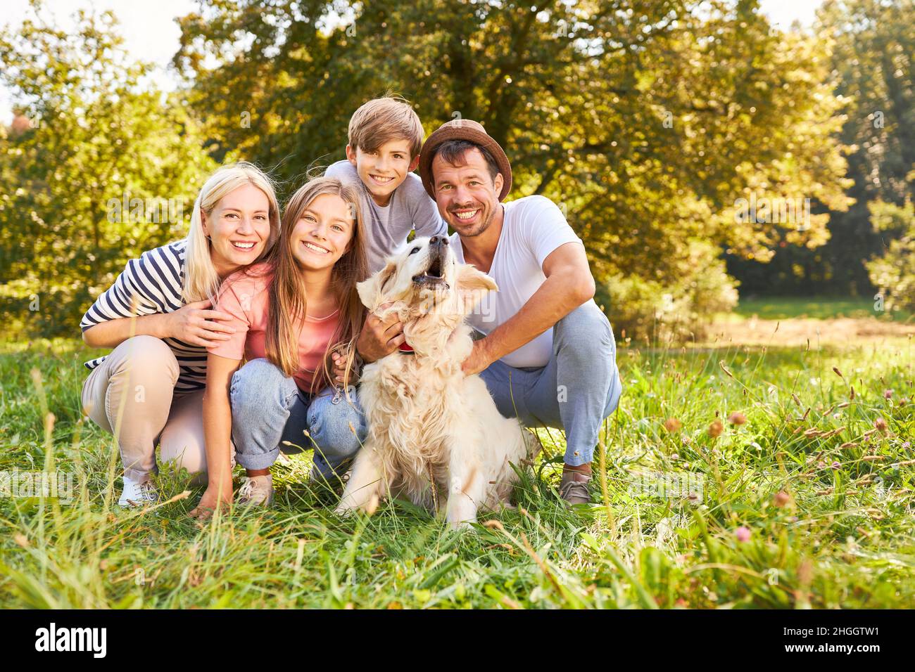 Happy family with two children and retriever dog in summer in nature ...