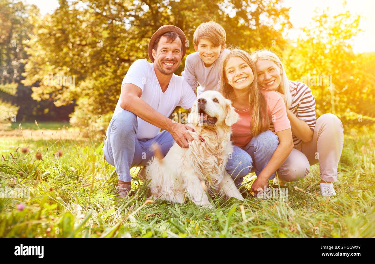 Happy family with son and daughter and dog in the garden in summer ...
