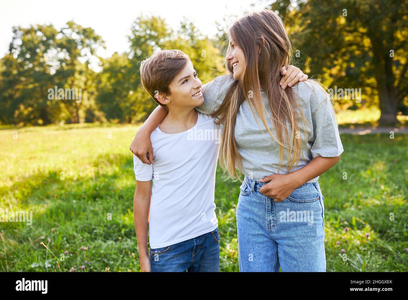 Brother and sister as happy siblings Children hug each other in park in ...