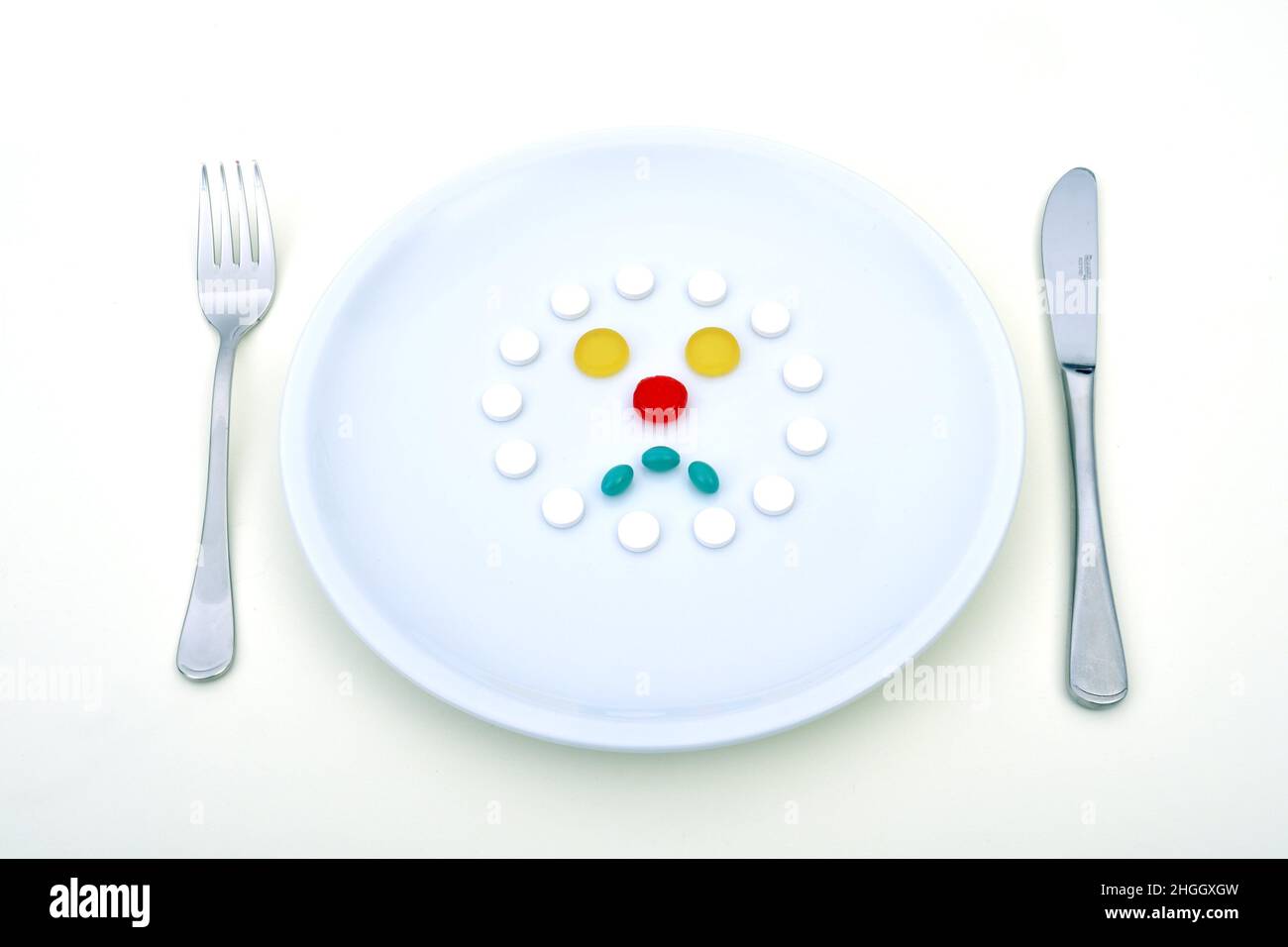 plate with pills in the shape of a face, symbolic image for synthetic ...