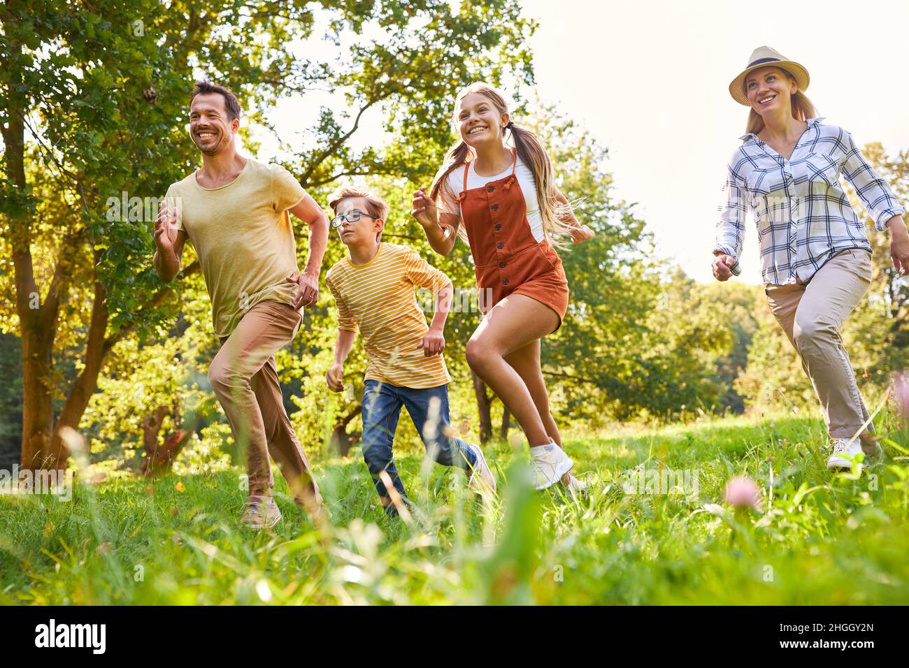 Athletic family with son and daughter running a race across a green ...