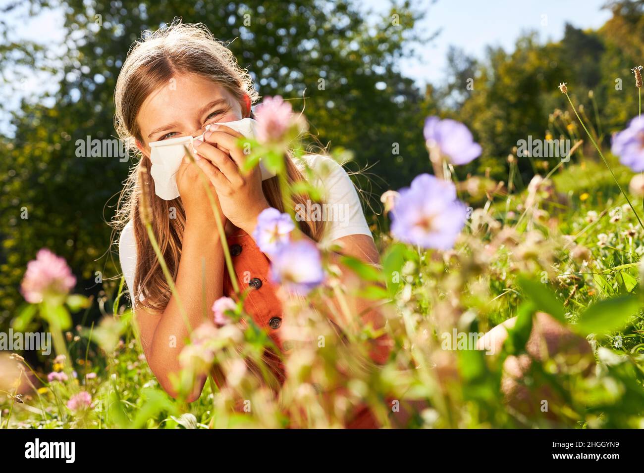 Girl with pollen allergy and hay fever sneezes into the handkerchief ...