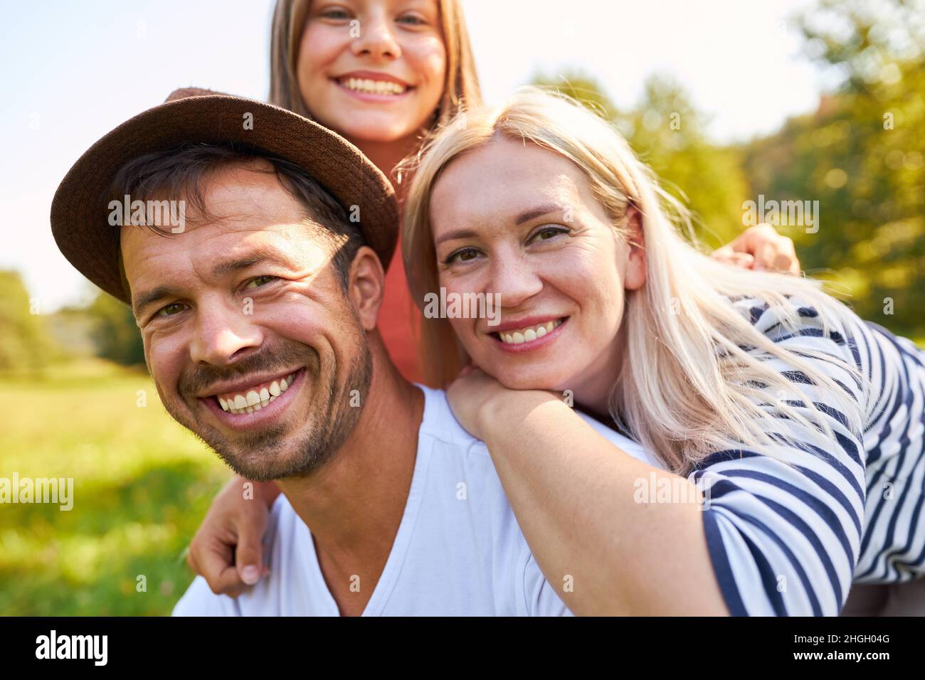 Happy parents and daughter together on a summer excursion in nature ...