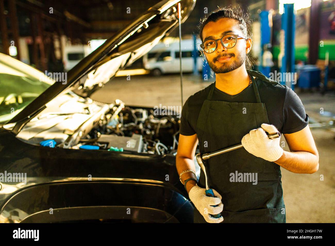 Auto mechanic standing in his workshop in sunset light background Stock ...