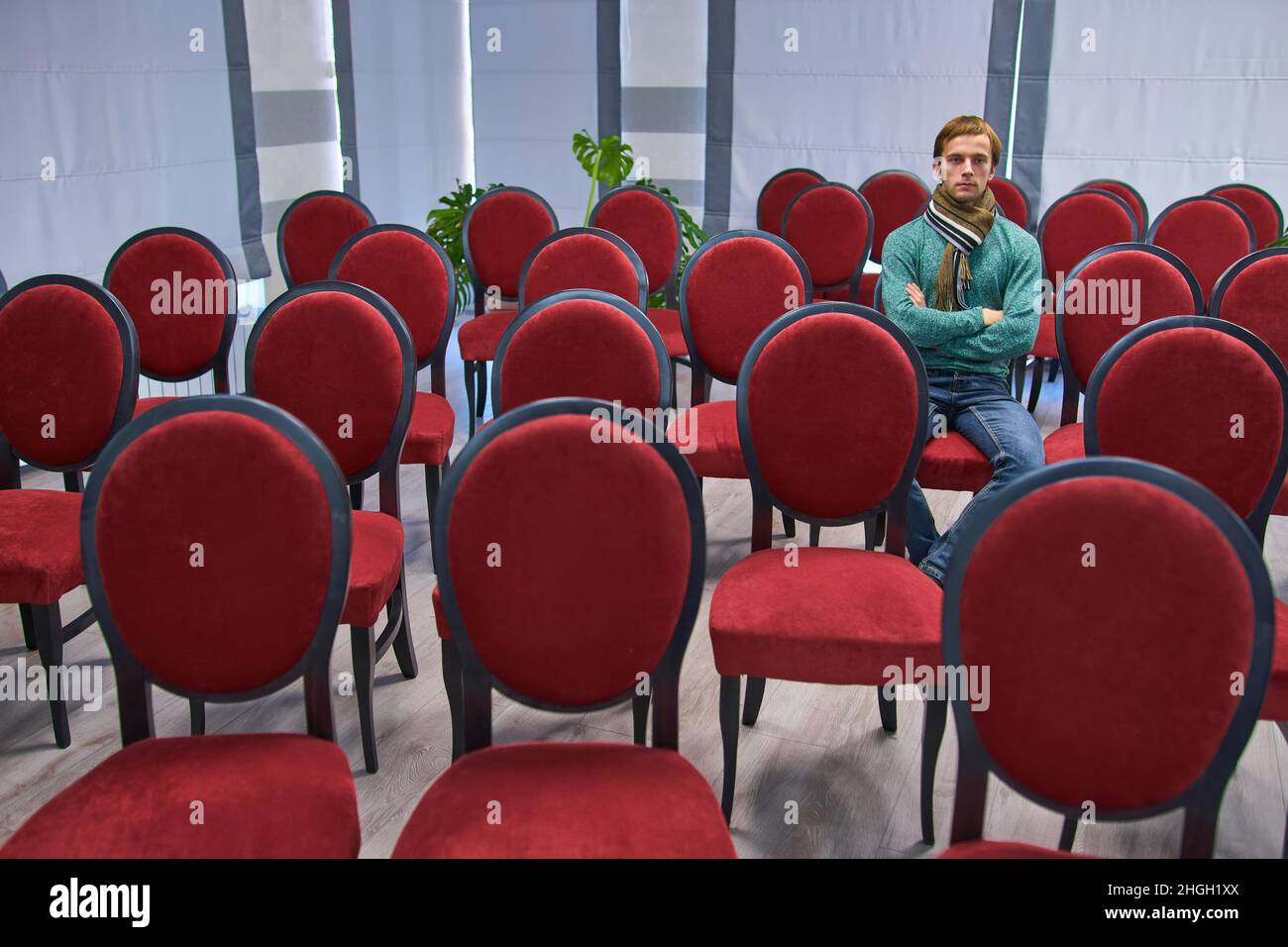 one man sitting in empty cinema or theater auditorium Stock Photo - Alamy