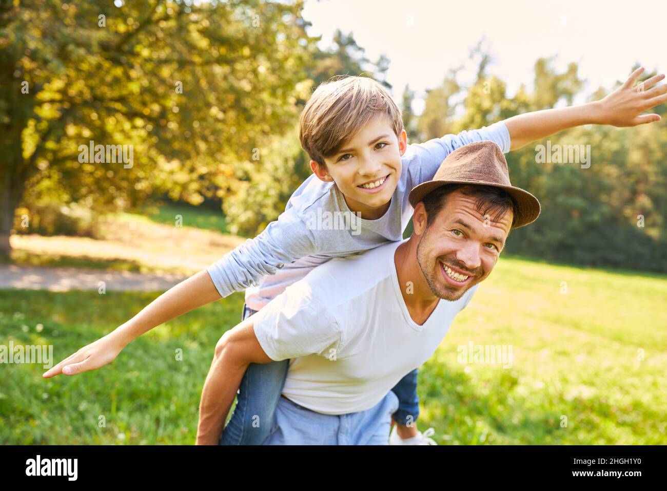 Happy boy playing piggyback on father's back in summer Stock Photo - Alamy