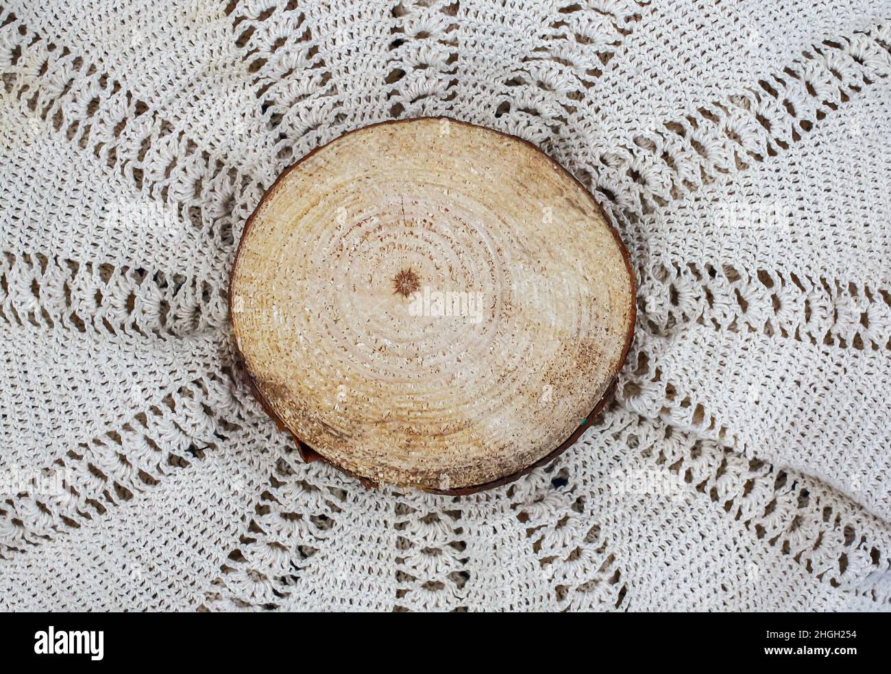 Wooden round slice on knitted natural surface Stock Photo - Alamy