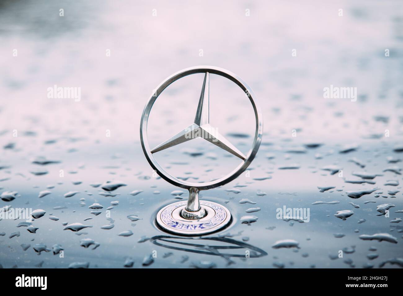 Close View Of Metal Star Logo Of Mercedes Benz At Wet Hood Of Blue Car ...