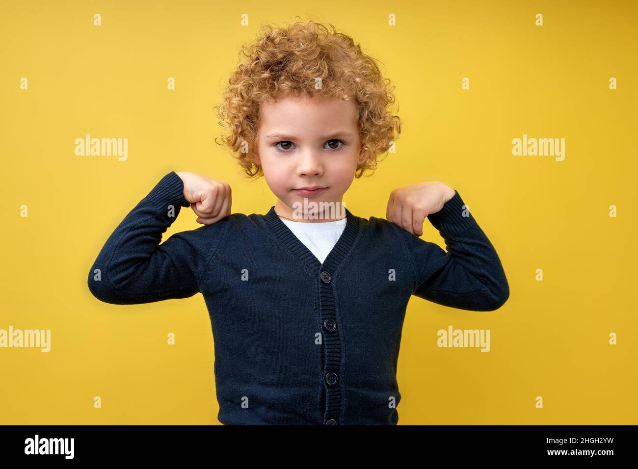 Look at my muscle, I'm strong. Portrait of confident little boy in T ...