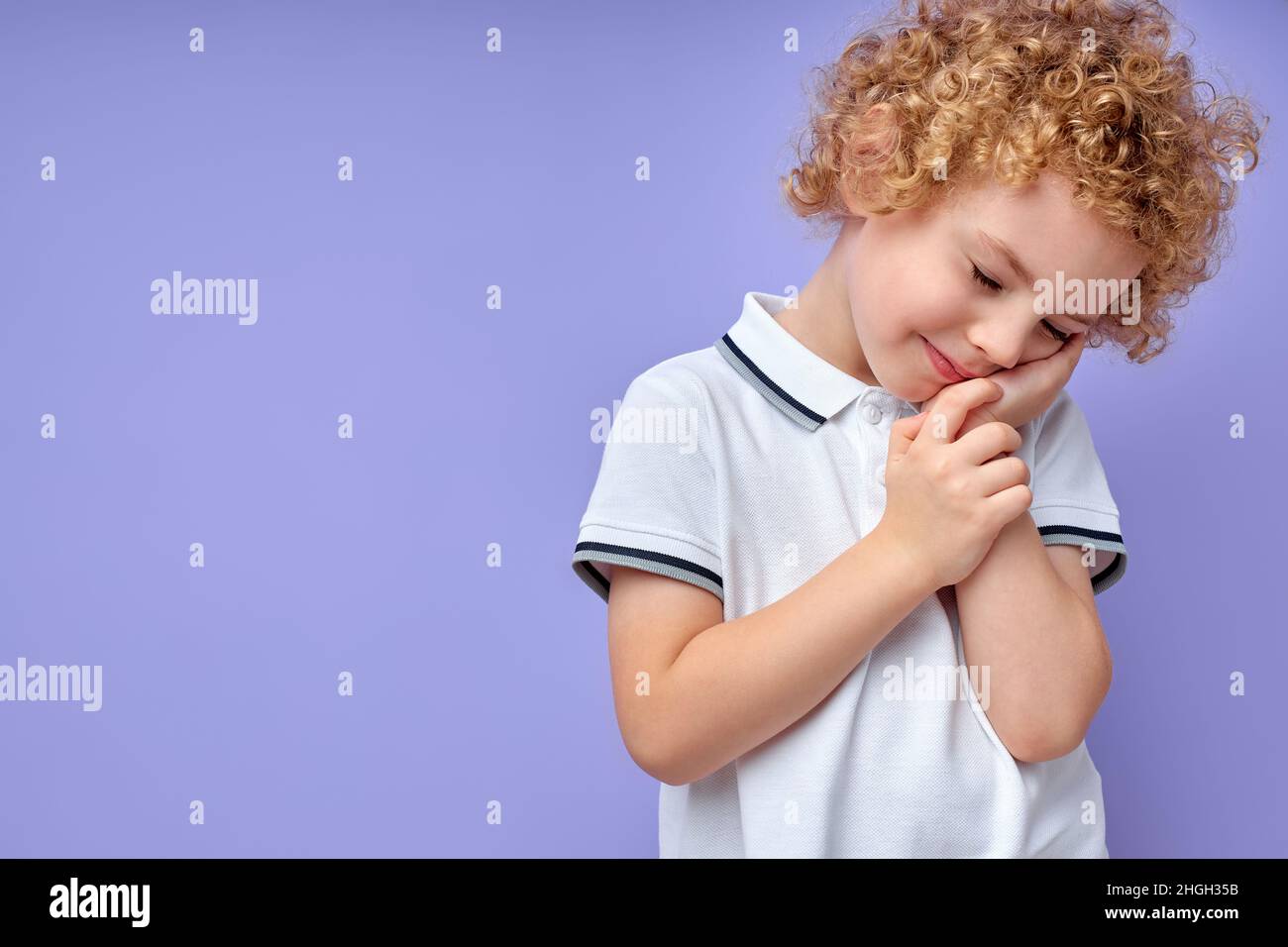 Cute child boy is leaned on hand, smiling, enjoying rest sleep after ...
