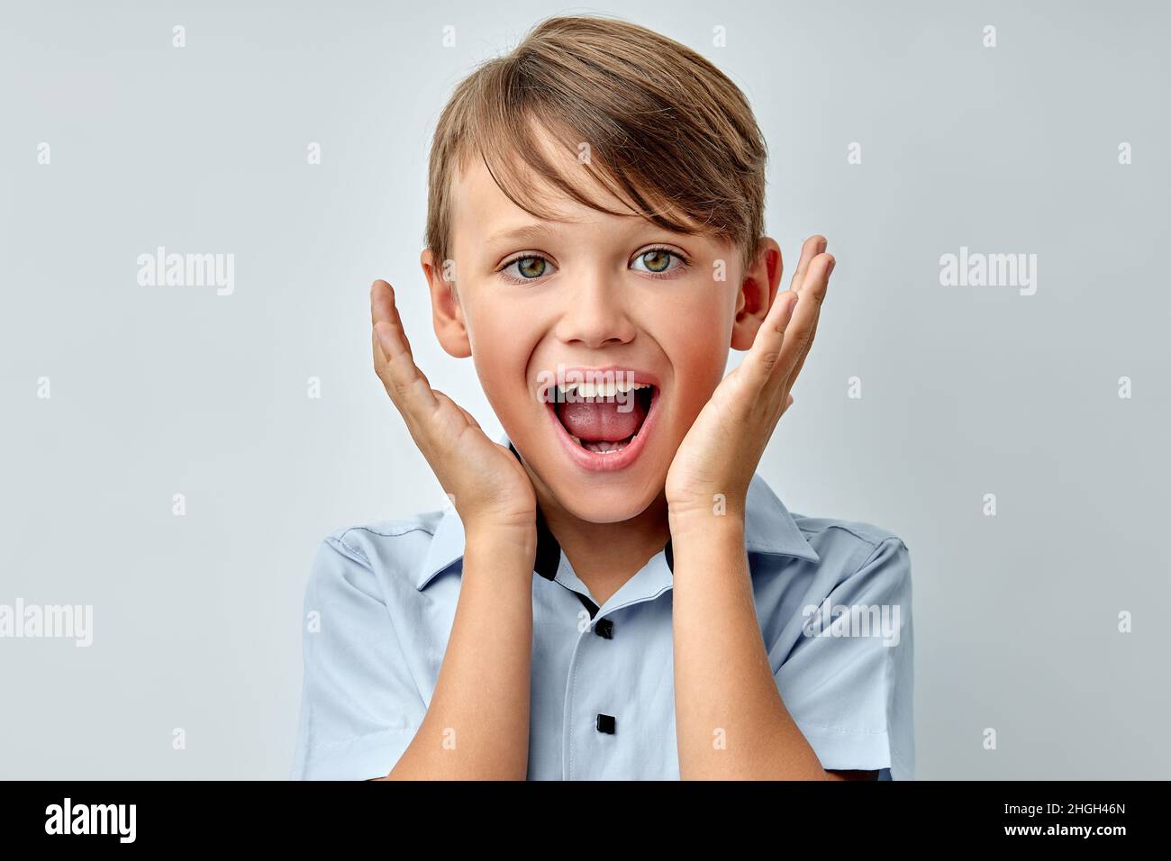 emotional little boy amazed touching face with opened mouth isolated ...