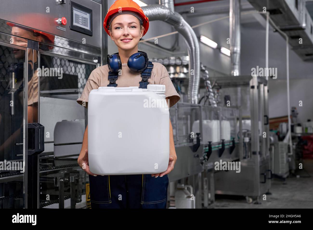 engineer woman in hardhat holding pesticide canister bottle, posing ...