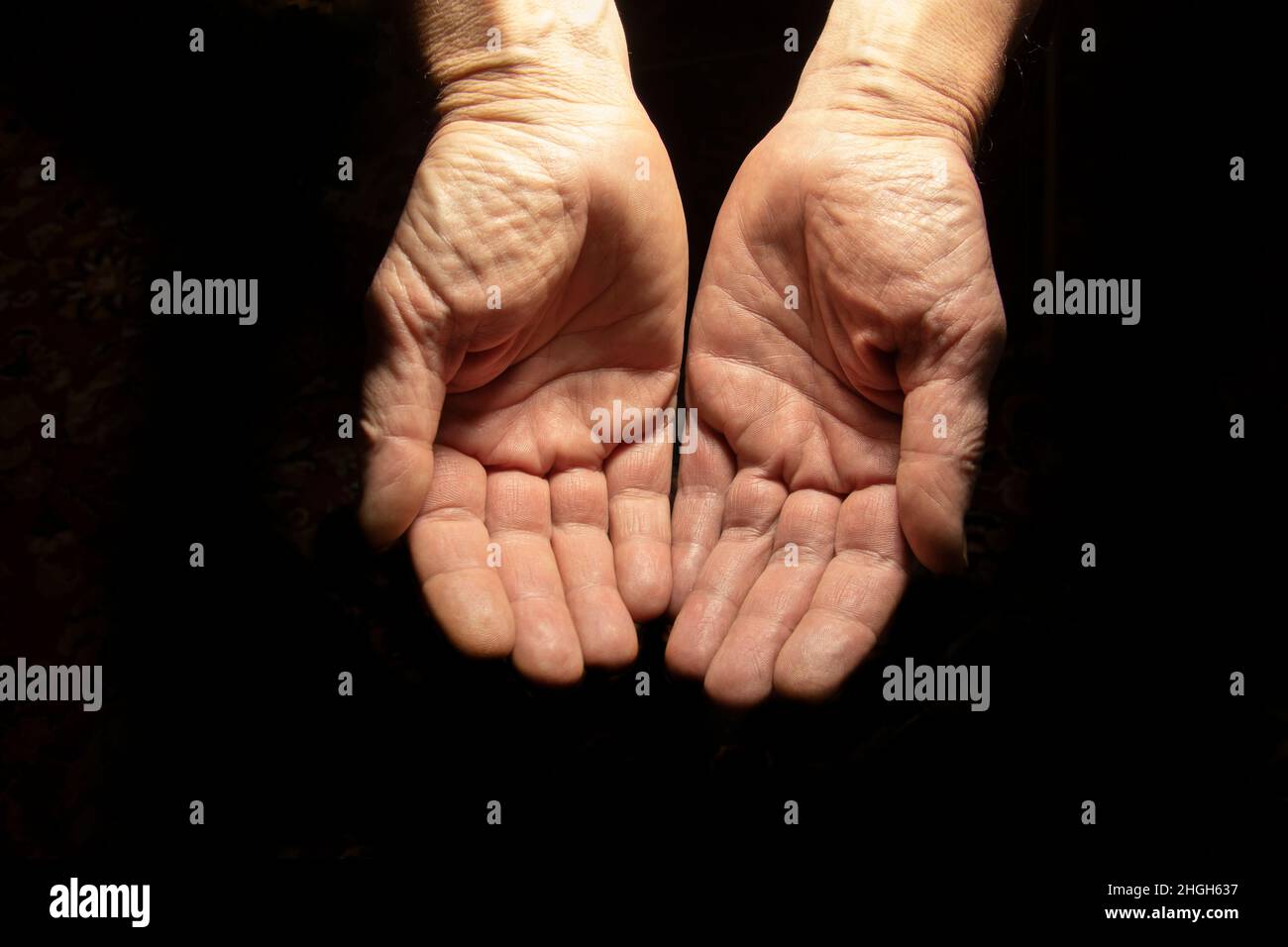 Two hands on a black background. The concept of asking for help Stock ...