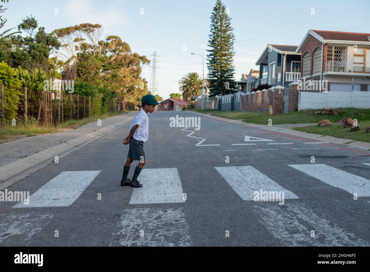 Young boy walking across zebra crossing Stock Photo - Alamy