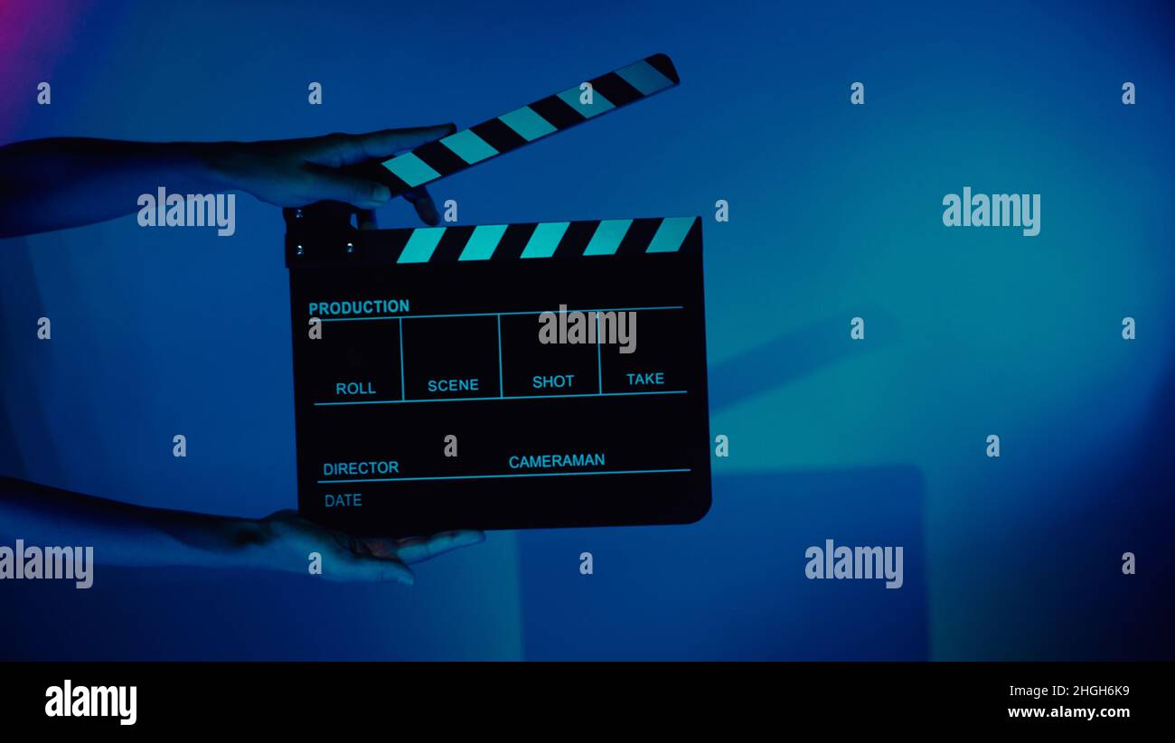 Blurry images of movie slate or clapper board. Hand holds empty film ...