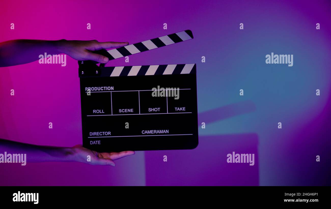 Blurry images of movie slate or clapper board. Hand holds empty film ...