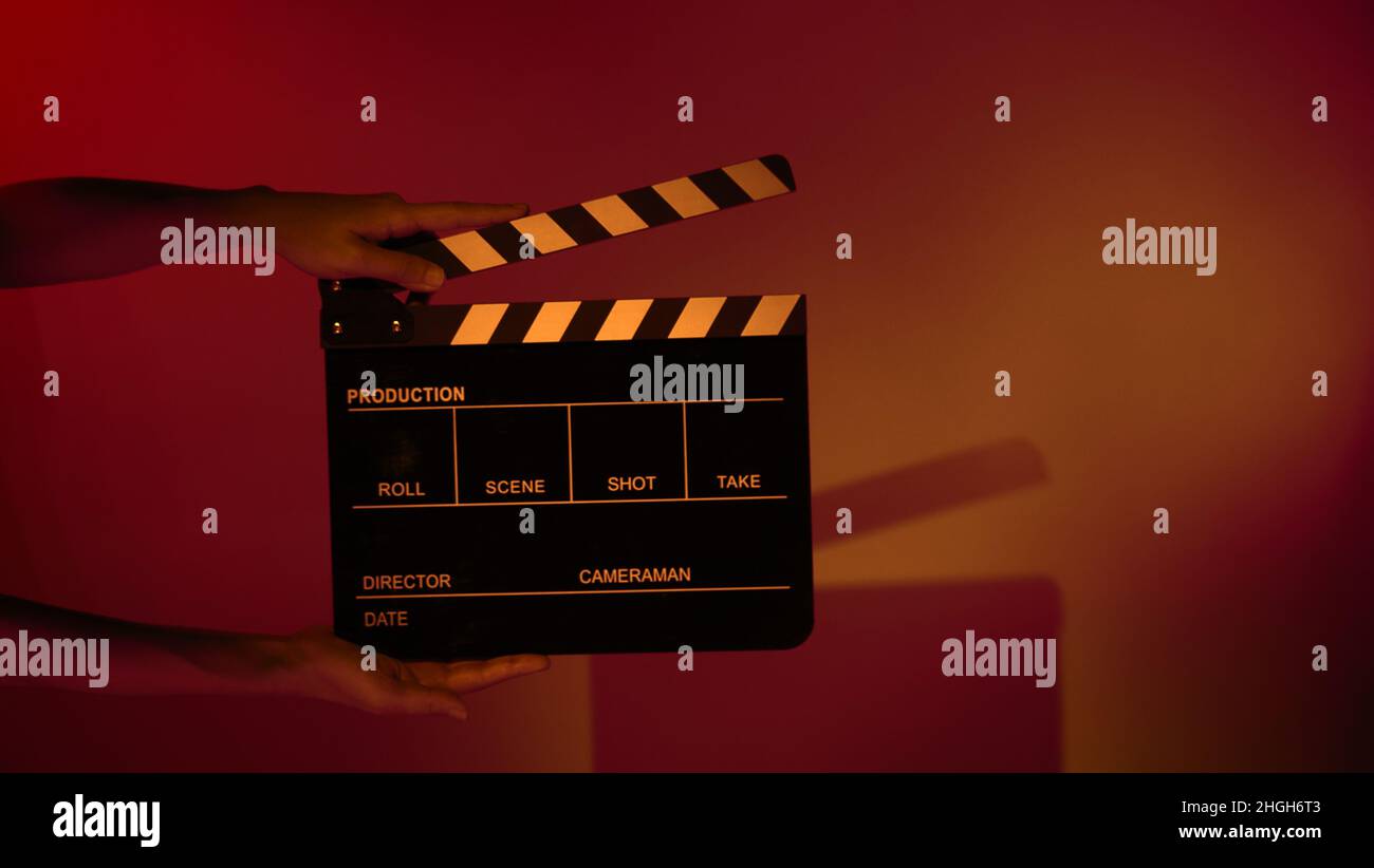 Blurry images of movie slate or clapper board. Hand holds empty film ...