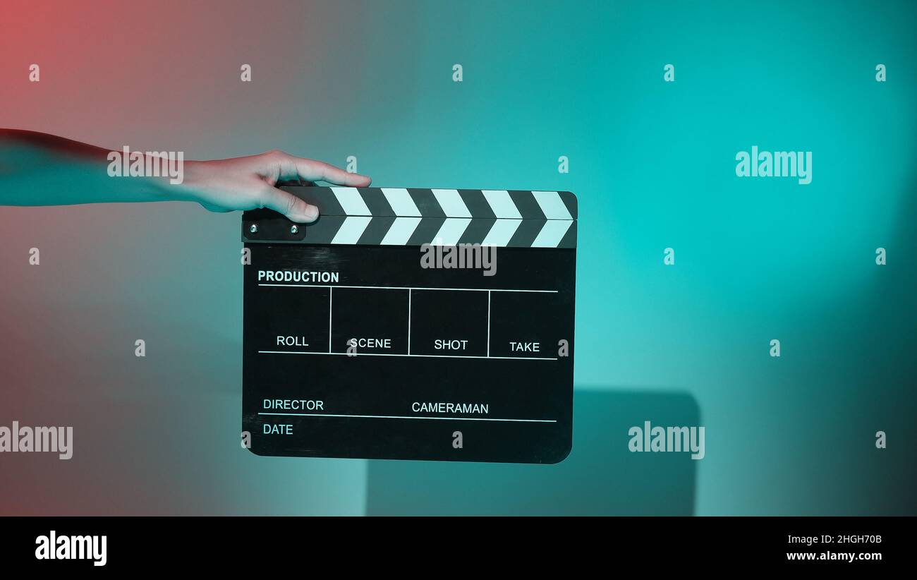 Blurry images of movie slate or clapper board. Hand holds empty film ...