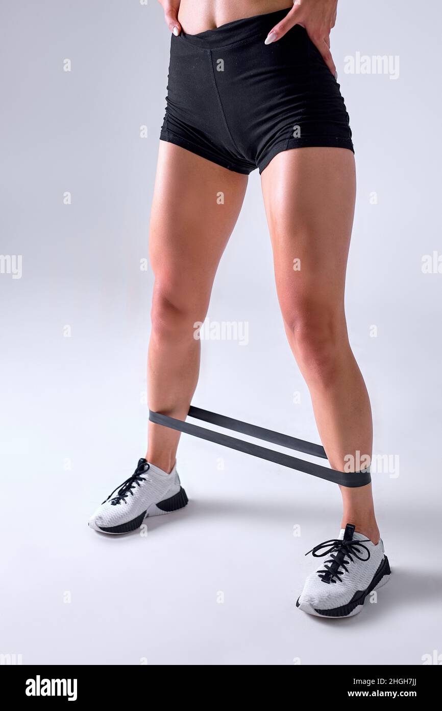 fit female is doing leg workout using elastic Resistance band for ...