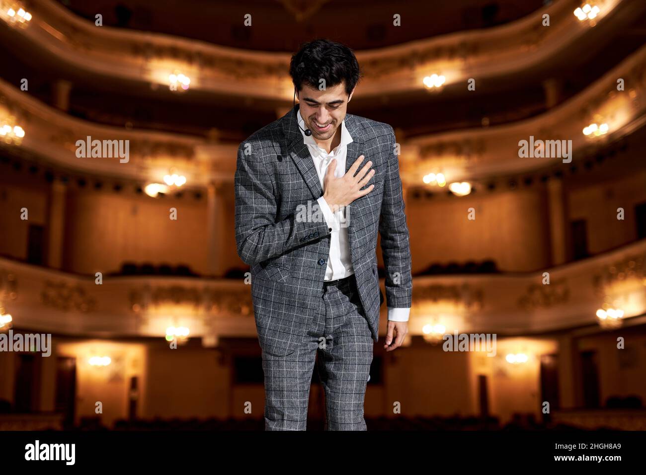 male Presenter in elegant classic suit on Stage is expressing gratitude ...