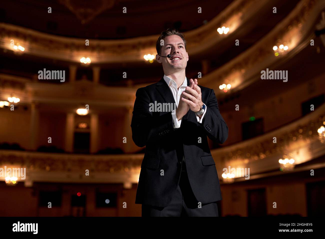 Actor or business couch standing on stage clapping hands, keep hands ...