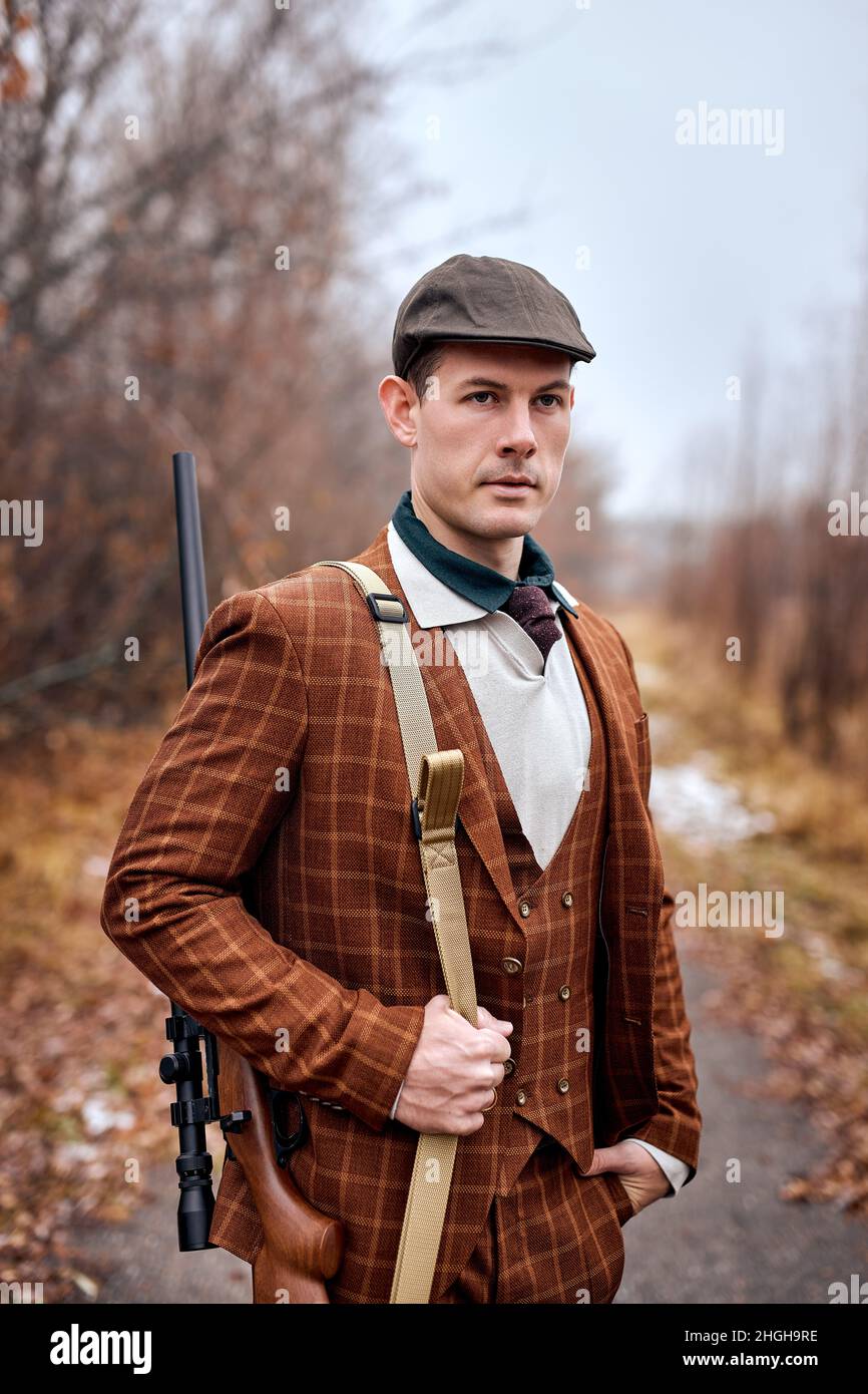 confident male hunter is going to hunt, dressed in brown stylish suit ...