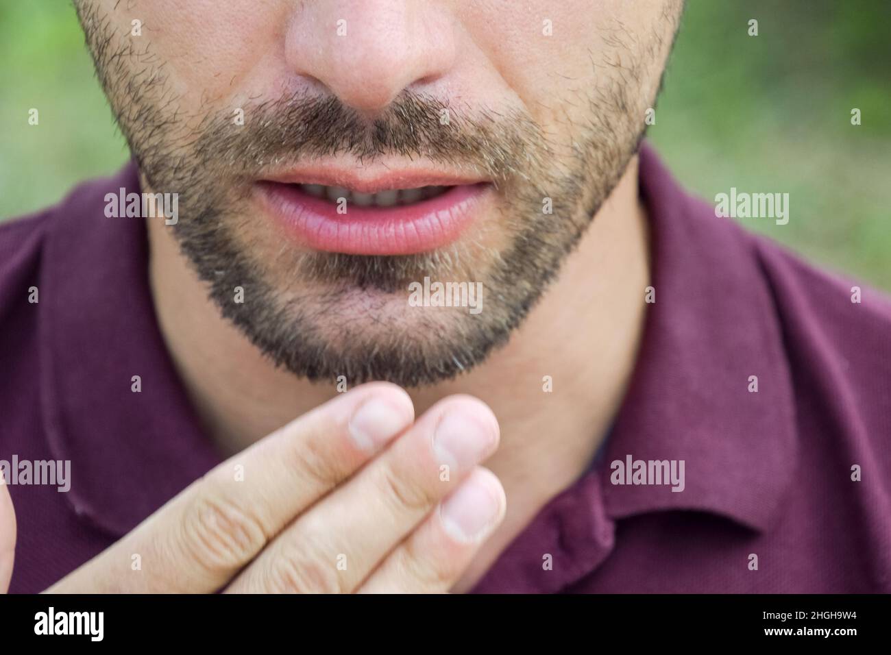 A bearded man covers his face with his palm. Beard on the face of a ...