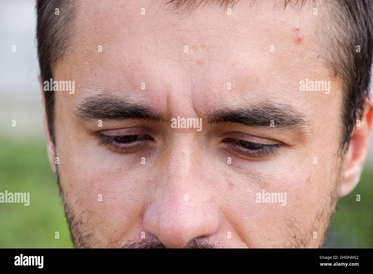 The man's gaze is directed downwards. a tired look Stock Photo - Alamy
