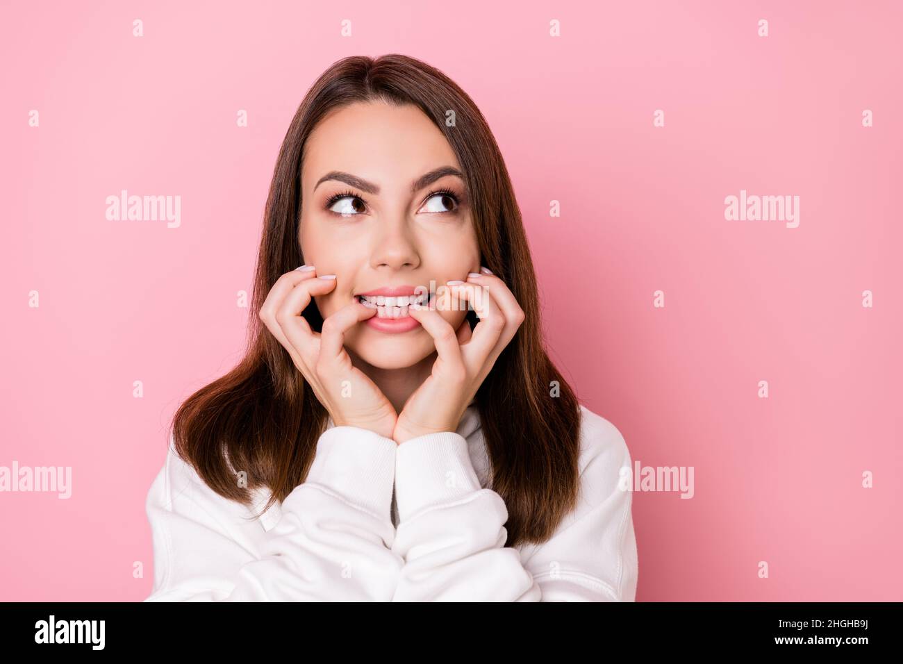 Photo Of Young Girl Happy Positive Smile Bite Fingers Lips Look Empty Space Isolated Over Pink