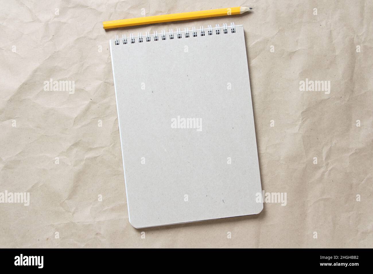 Gray notepad with white coiled spring and pencil on a background of ...