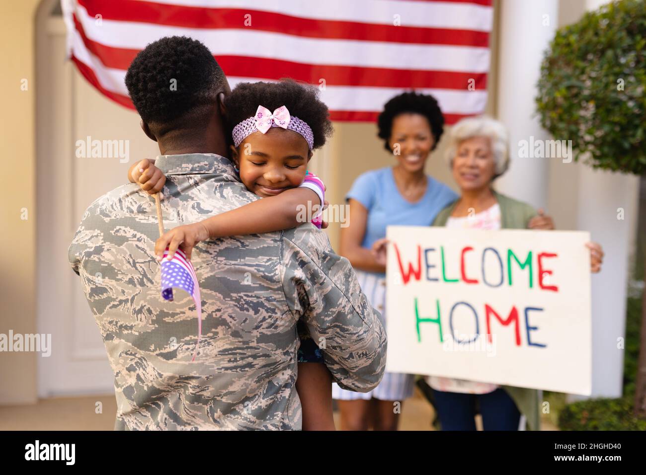 Smiling african american girl embracing soldier father on his return ...