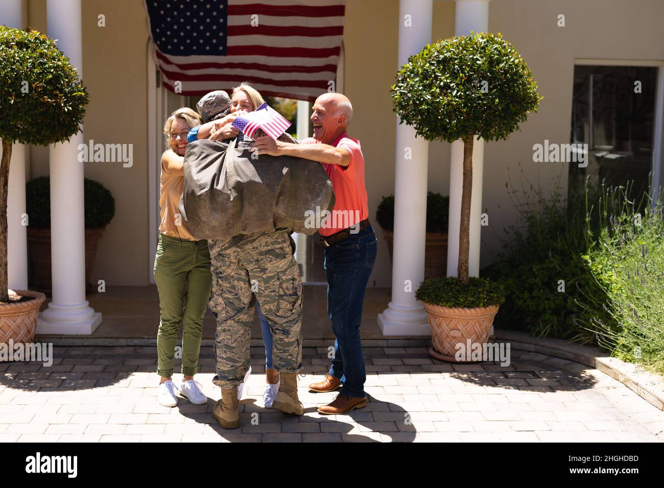 Happy caucasian family hugging military soldier on his return home at ...
