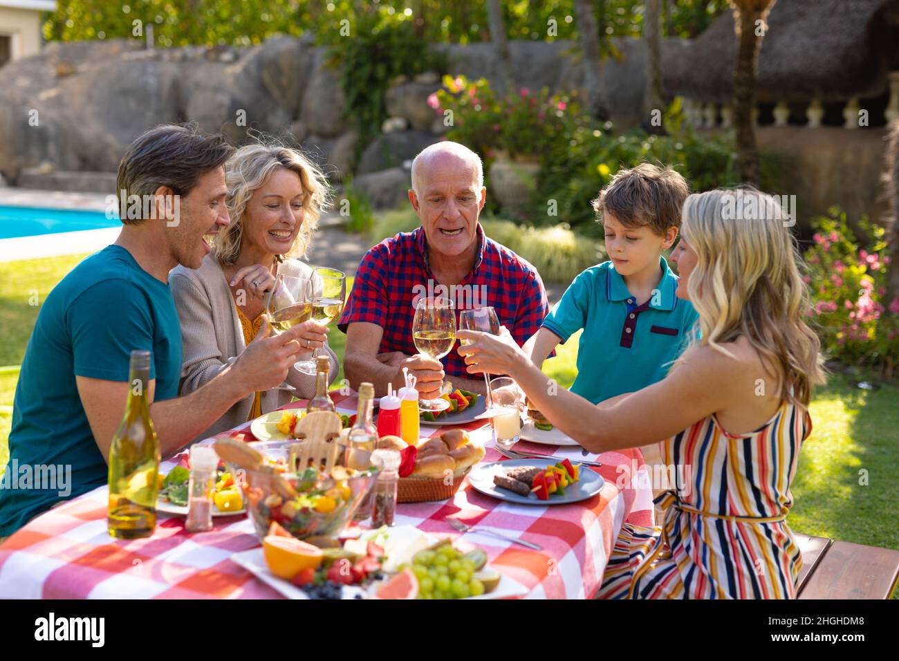 Happy caucasian family toasting drinks while sitting together at table ...