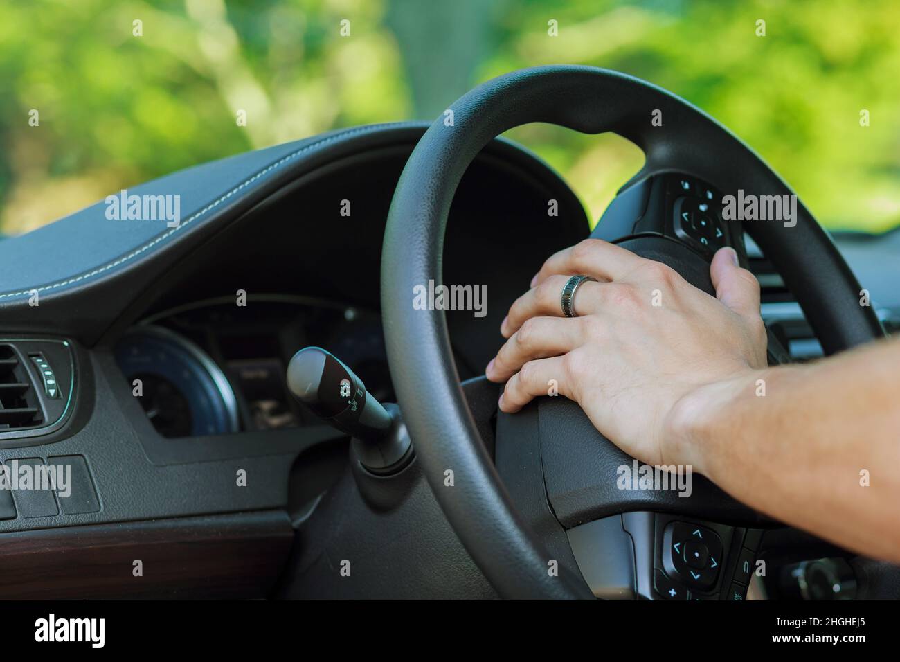 Man's hand on the steering wheel of a car Stock Photo - Alamy