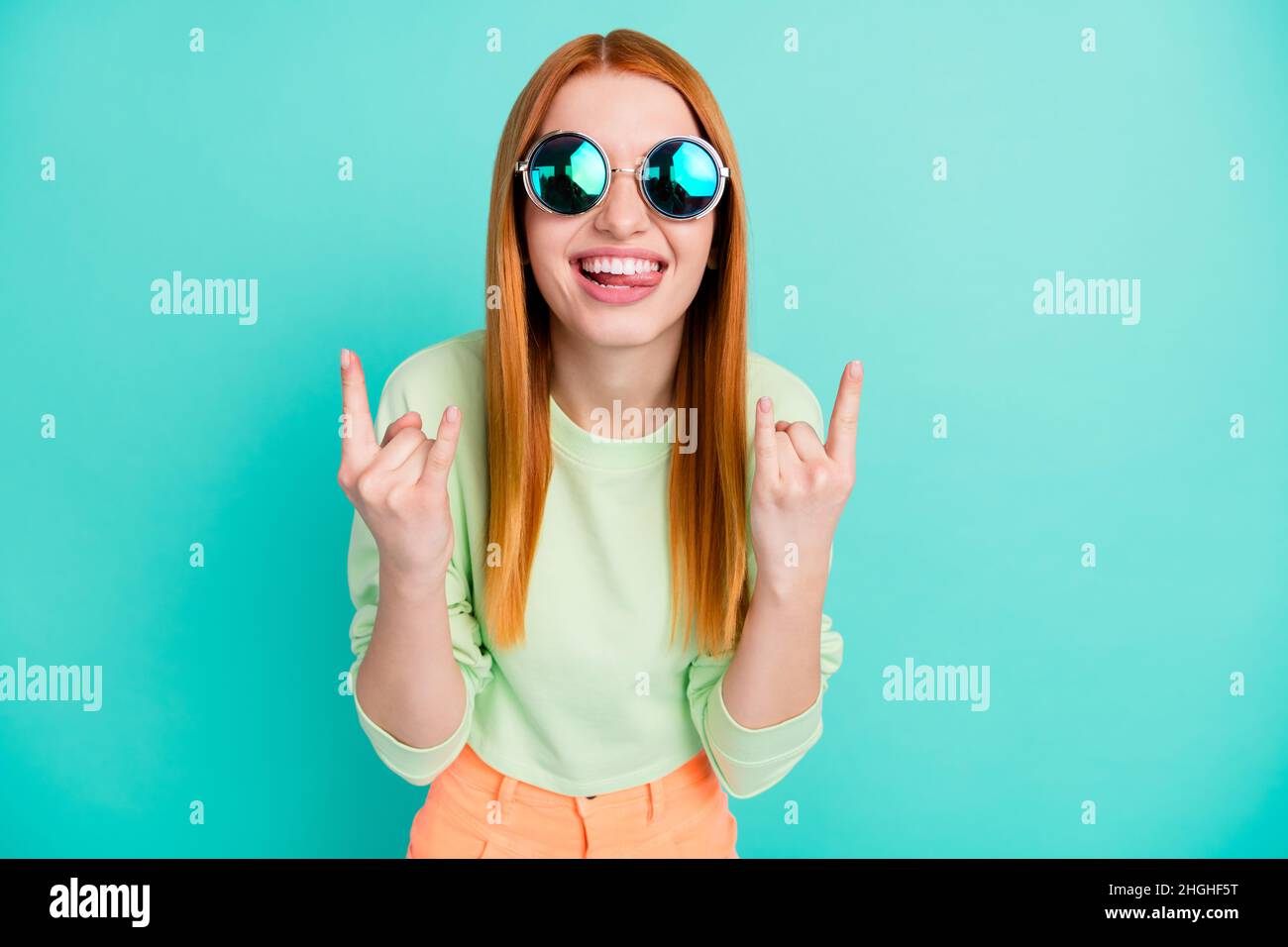 Photo of cool millennial lady tongue out show rock sign wear eyewear ...
