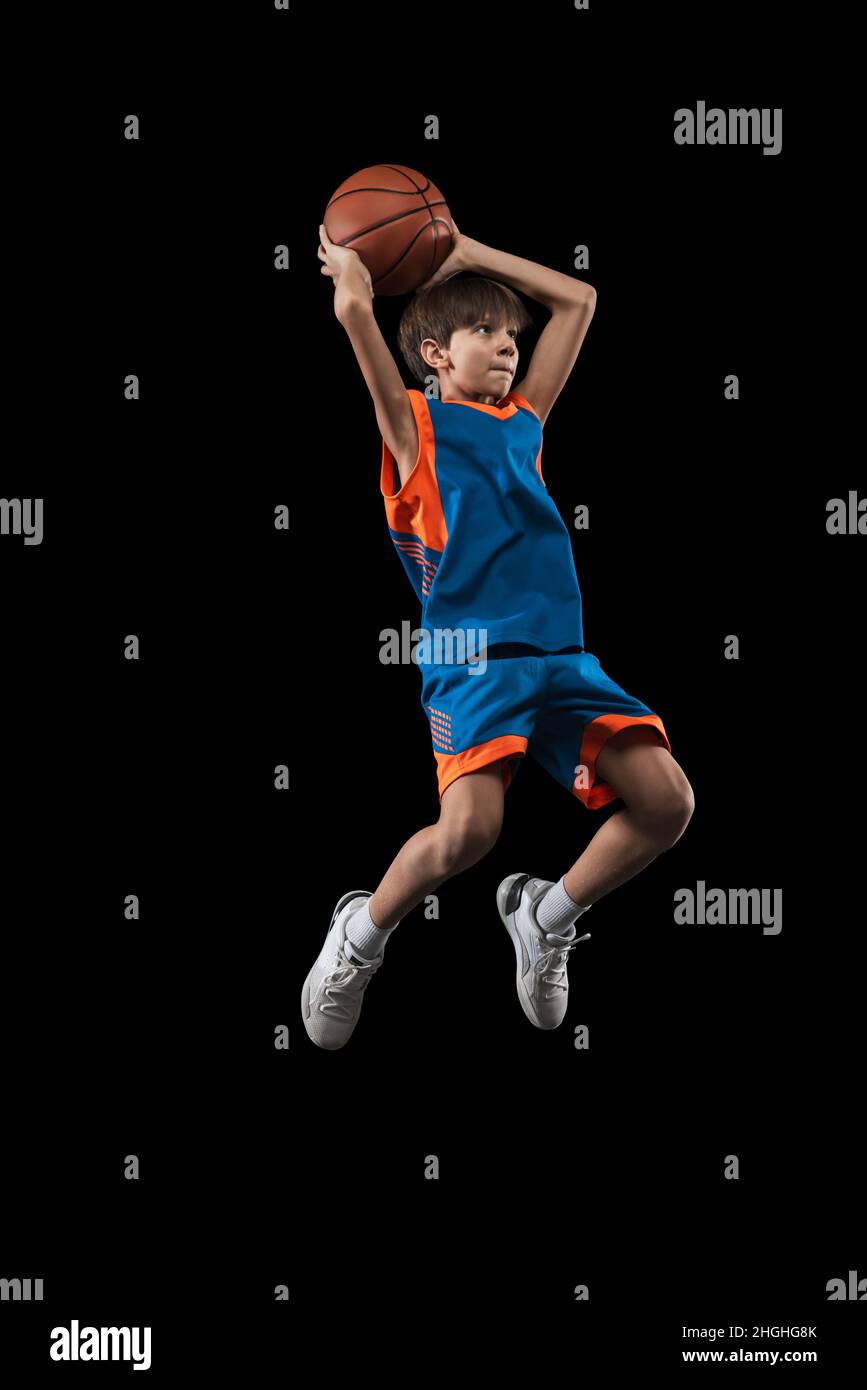Full-length studio portrait of youn boy, teenager throwing a ball in a ...