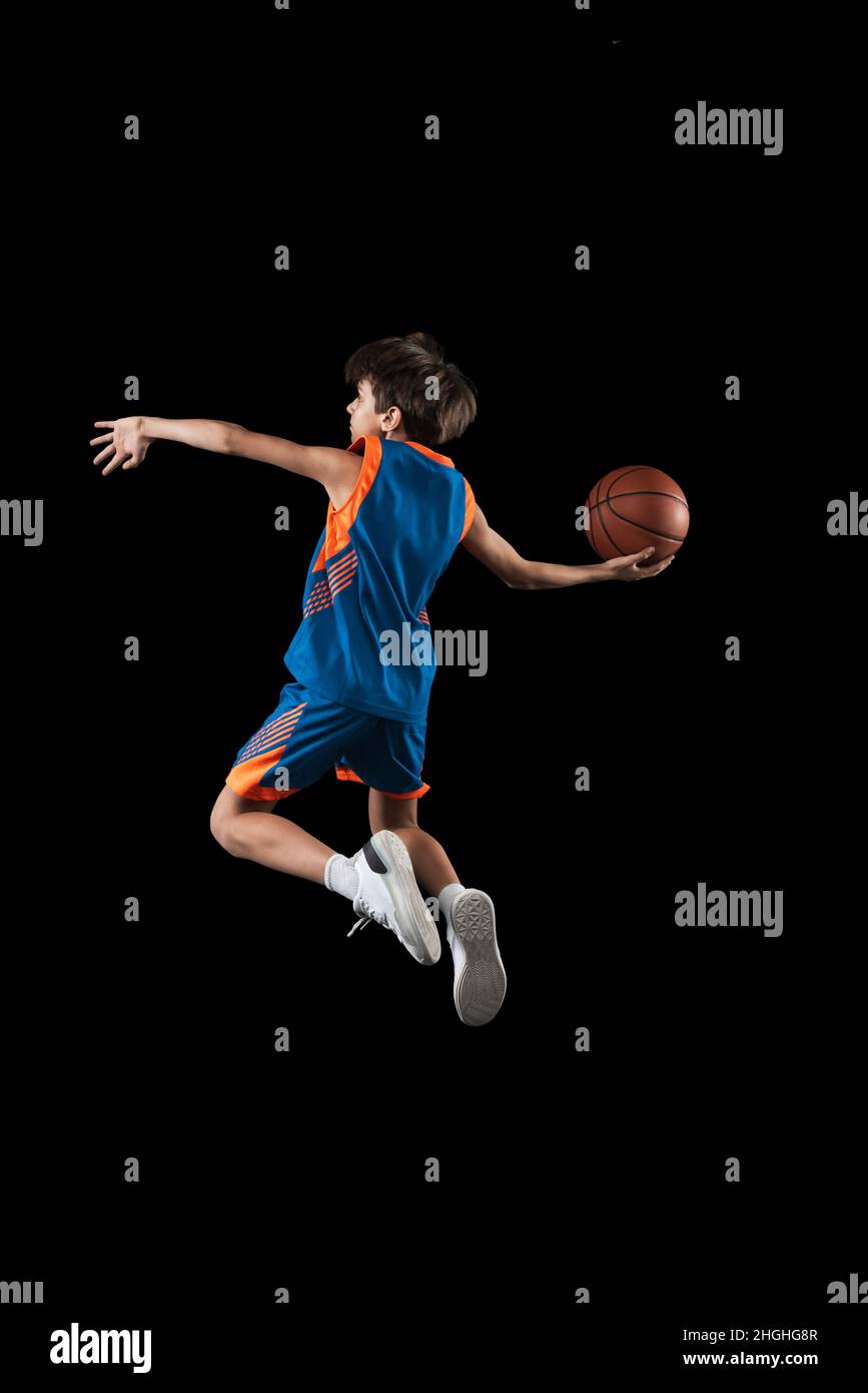 Back view studio shot of young boy, teenager playing basketball ...