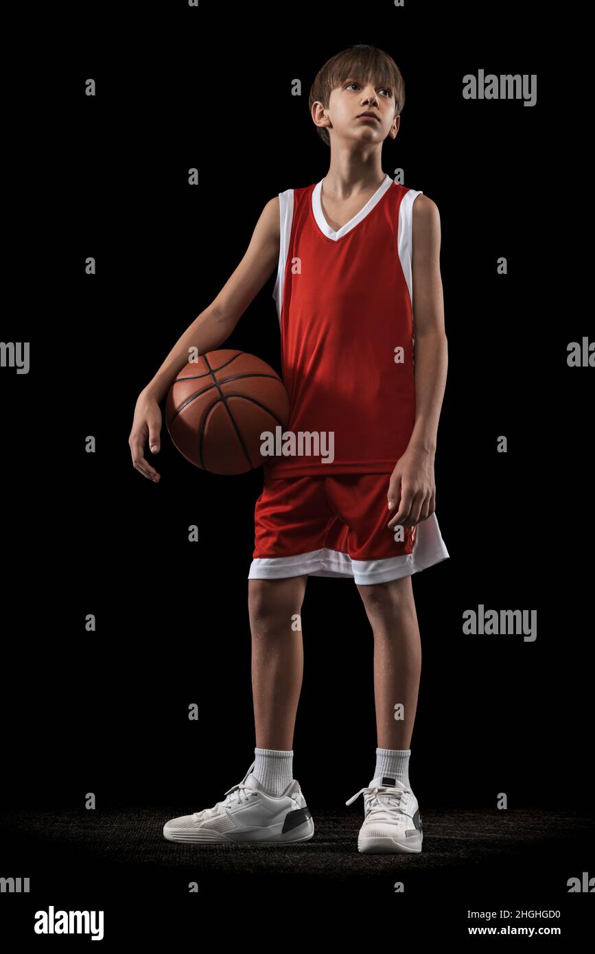 Full-length portrait of teen boy, basketball player in red uniform ...