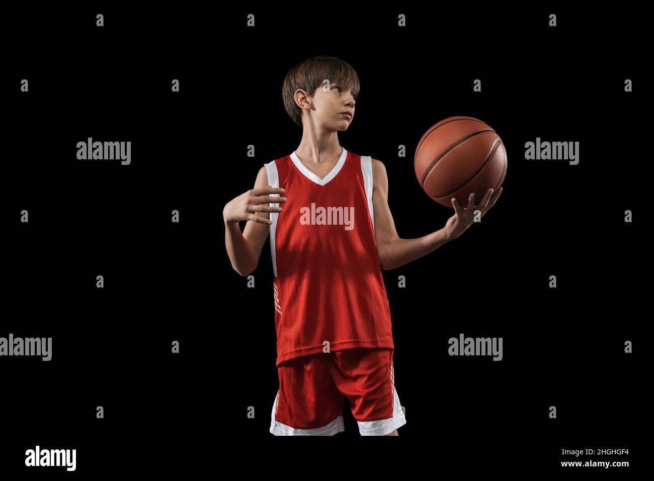 Cropped portrait of young boy, basketball player in red uniform ...