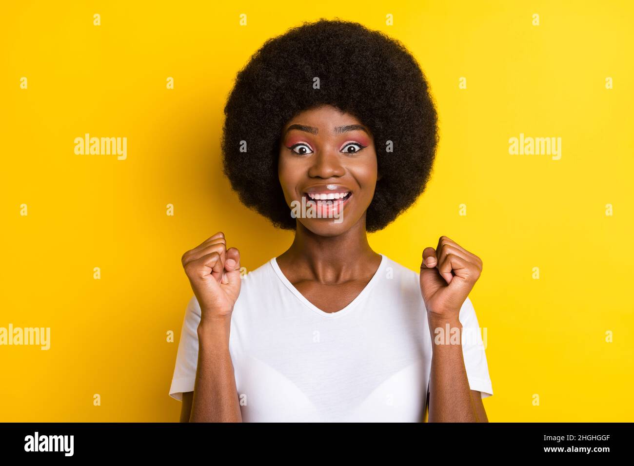 Photo of amazed cheerful dark skin young woman raise fists winner ...