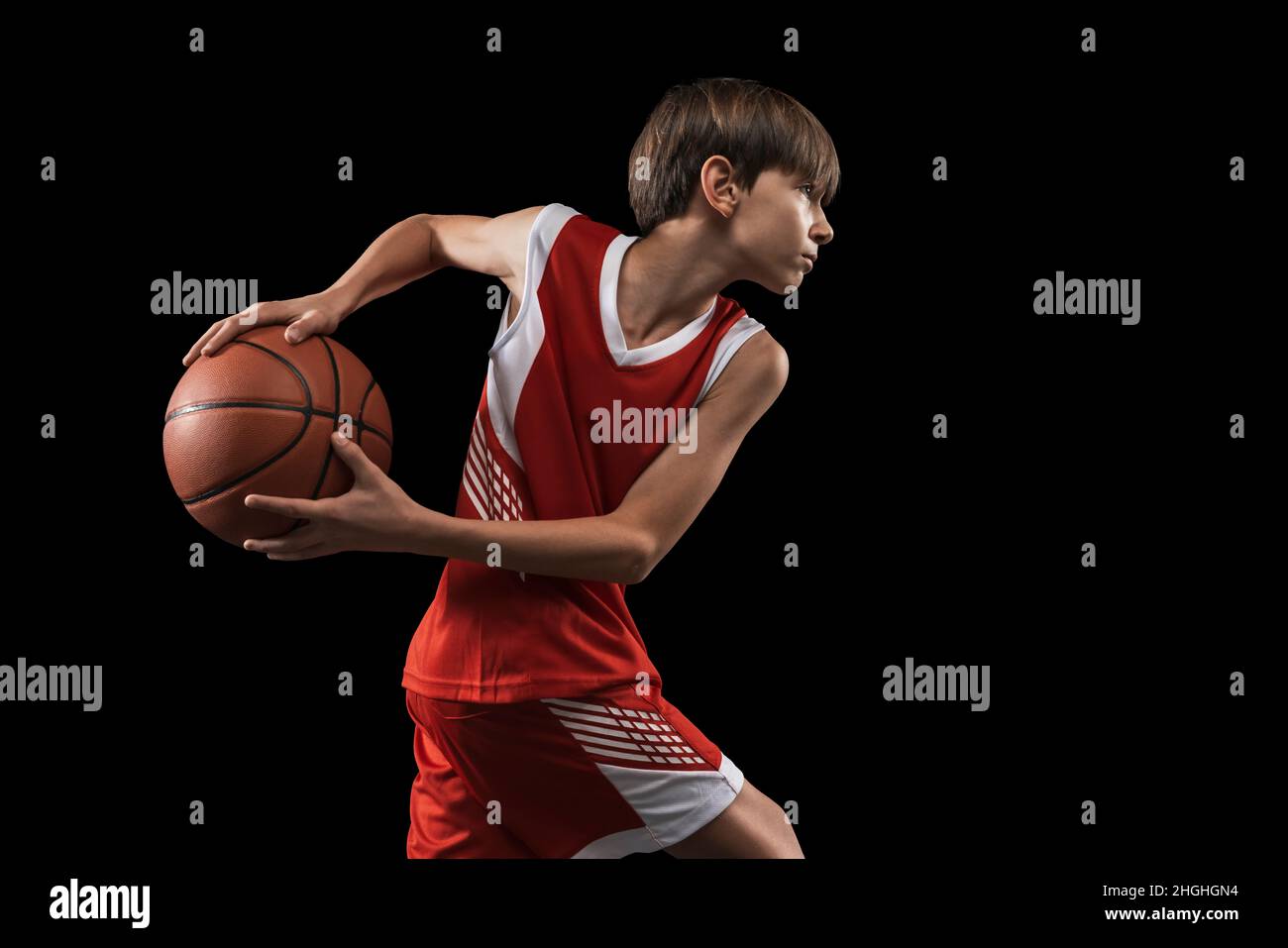 Cropped portrait of teen boy playing basketball isolated over black ...
