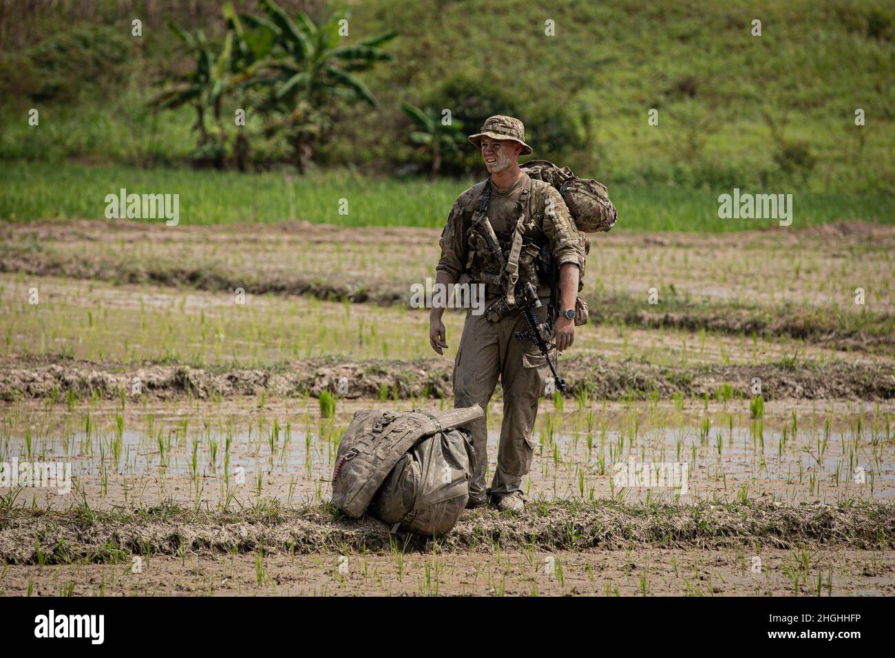A U.S. Army Soldier with the 82nd Airborne Division stands in a paddy ...