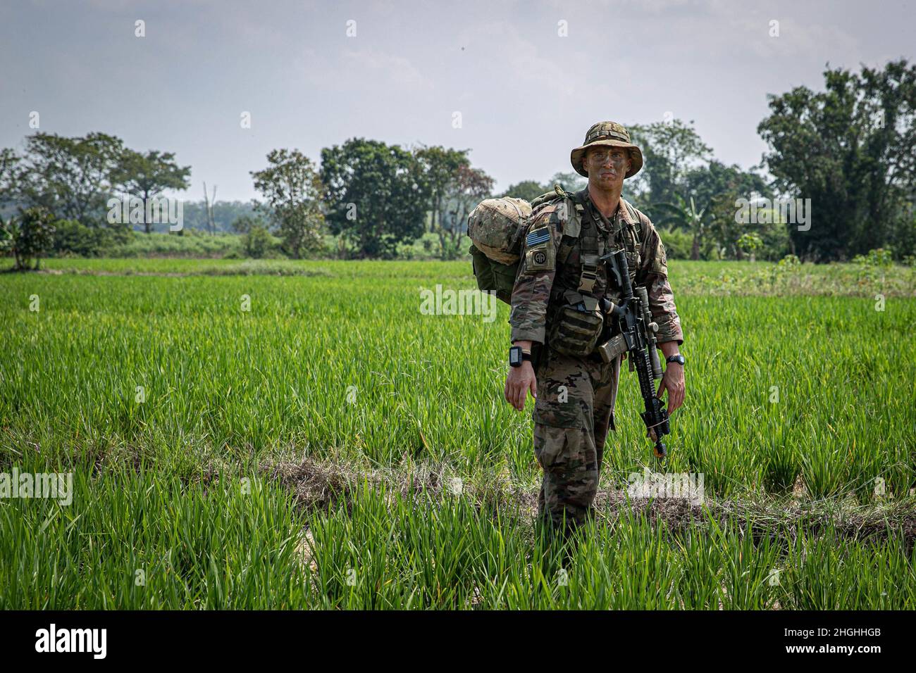 A U.S. Army Soldier with the 82nd Airborne Division stands in a paddy ...